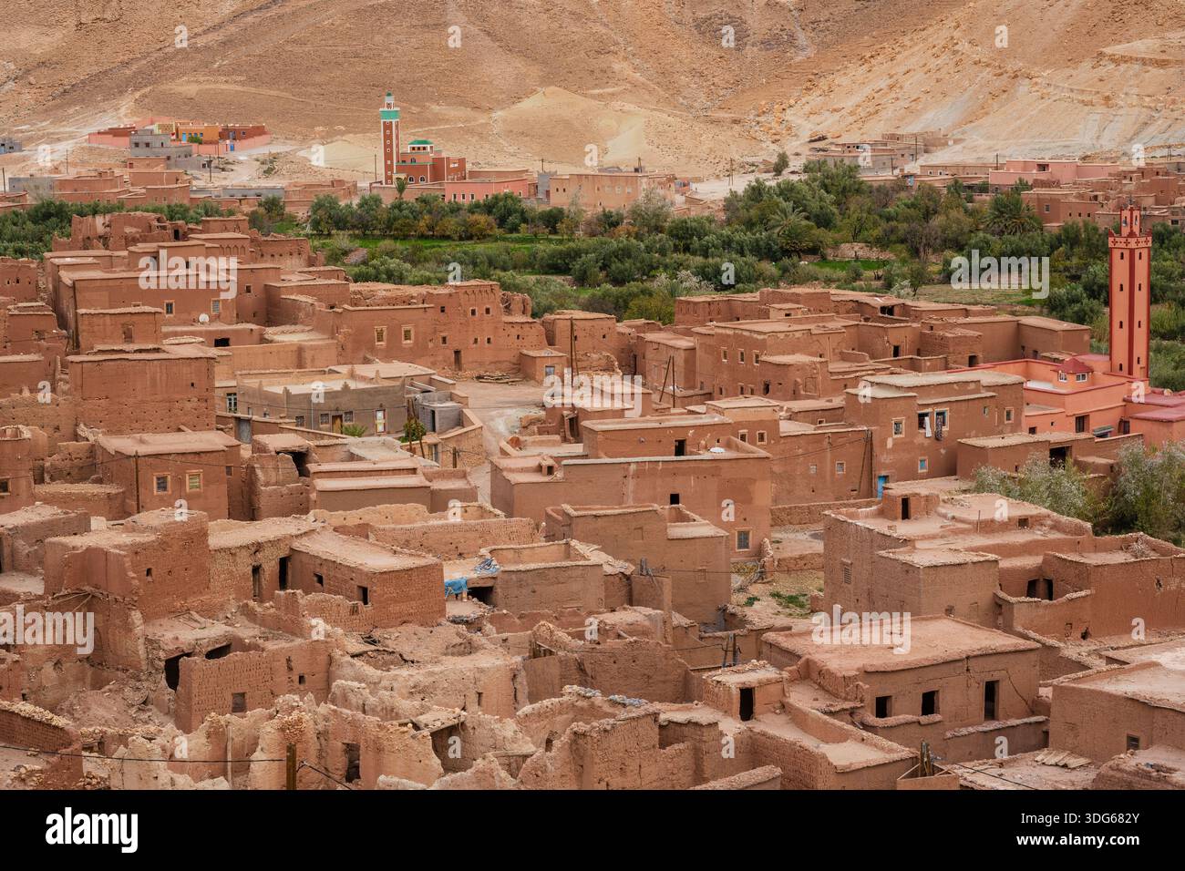 Ancient clay buildings and green landscape in a desert mountain village ...