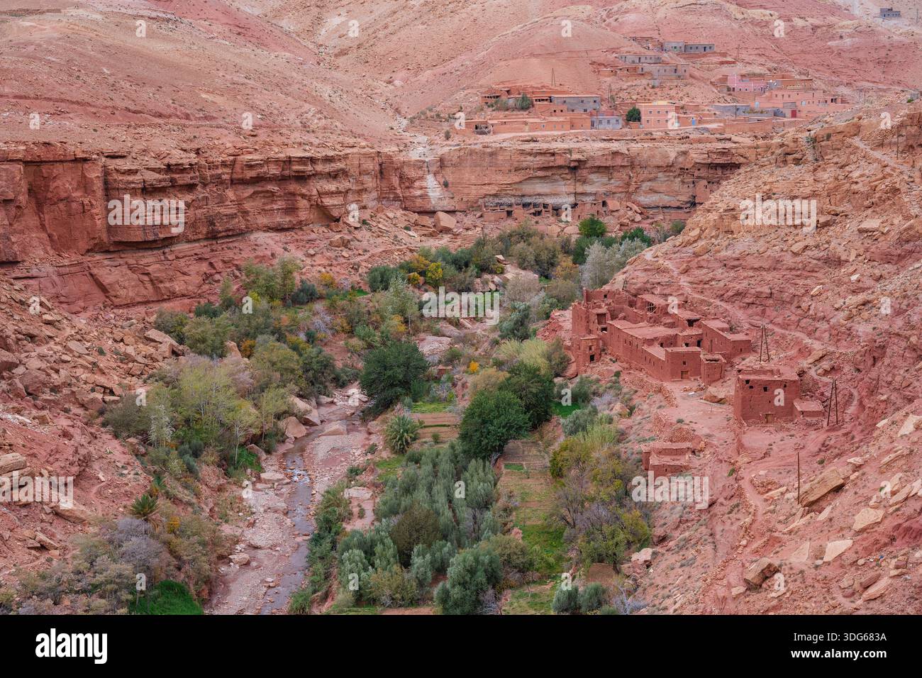 Red rocky canyon landscape with ancient clay buildings and lush ...
