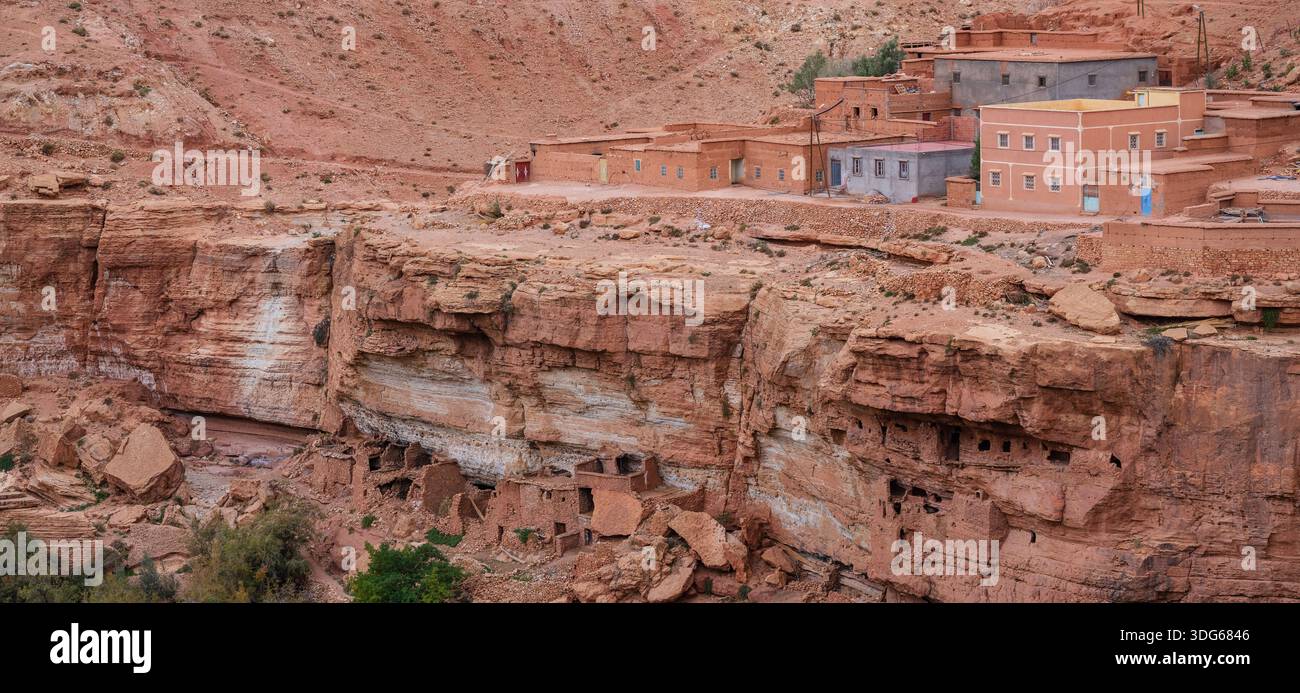 Cliffside village with rustic buildings set against a rocky desert ...