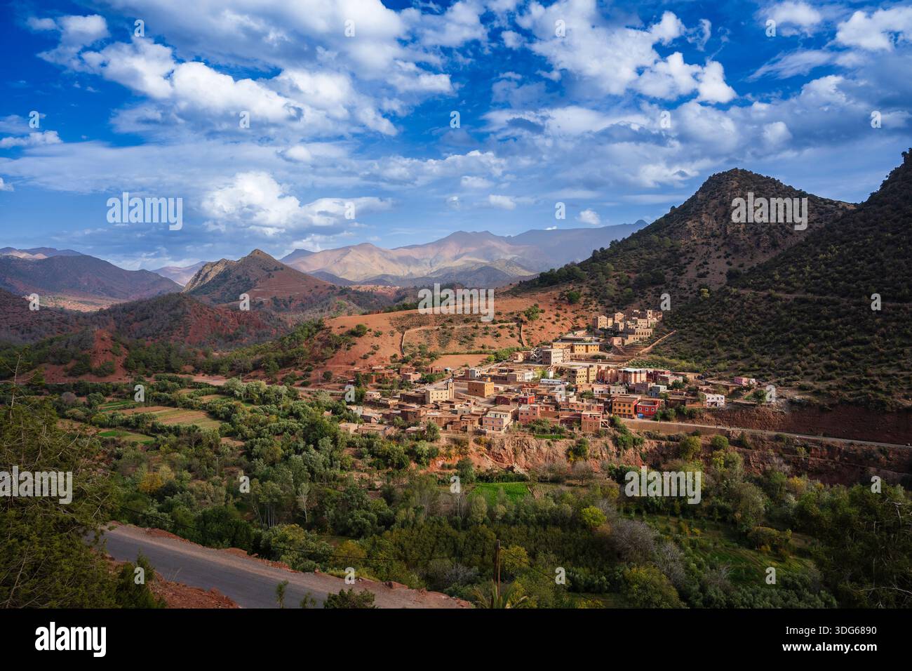 Scenic mountain village under a vibrant blue sky with scattered clouds ...