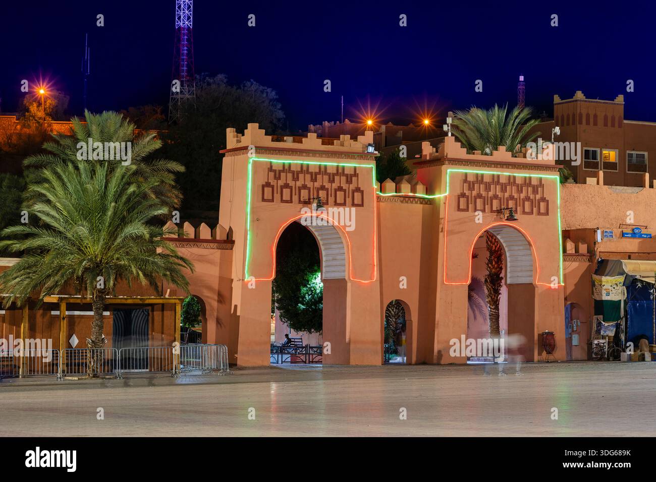 Brightly lit historic gate with neon lights framed by palm trees at ...