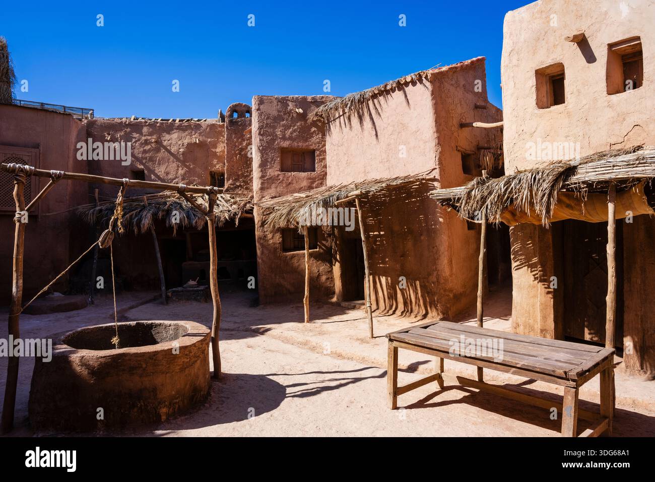 Rustic village scene under clear blue sky with stone buildings and ...