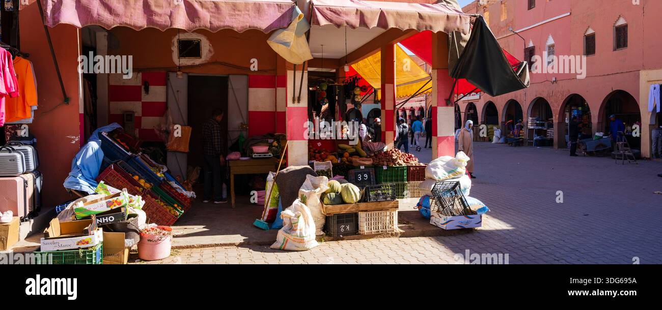 Colorful market stall with produce and goods under red and orange ...