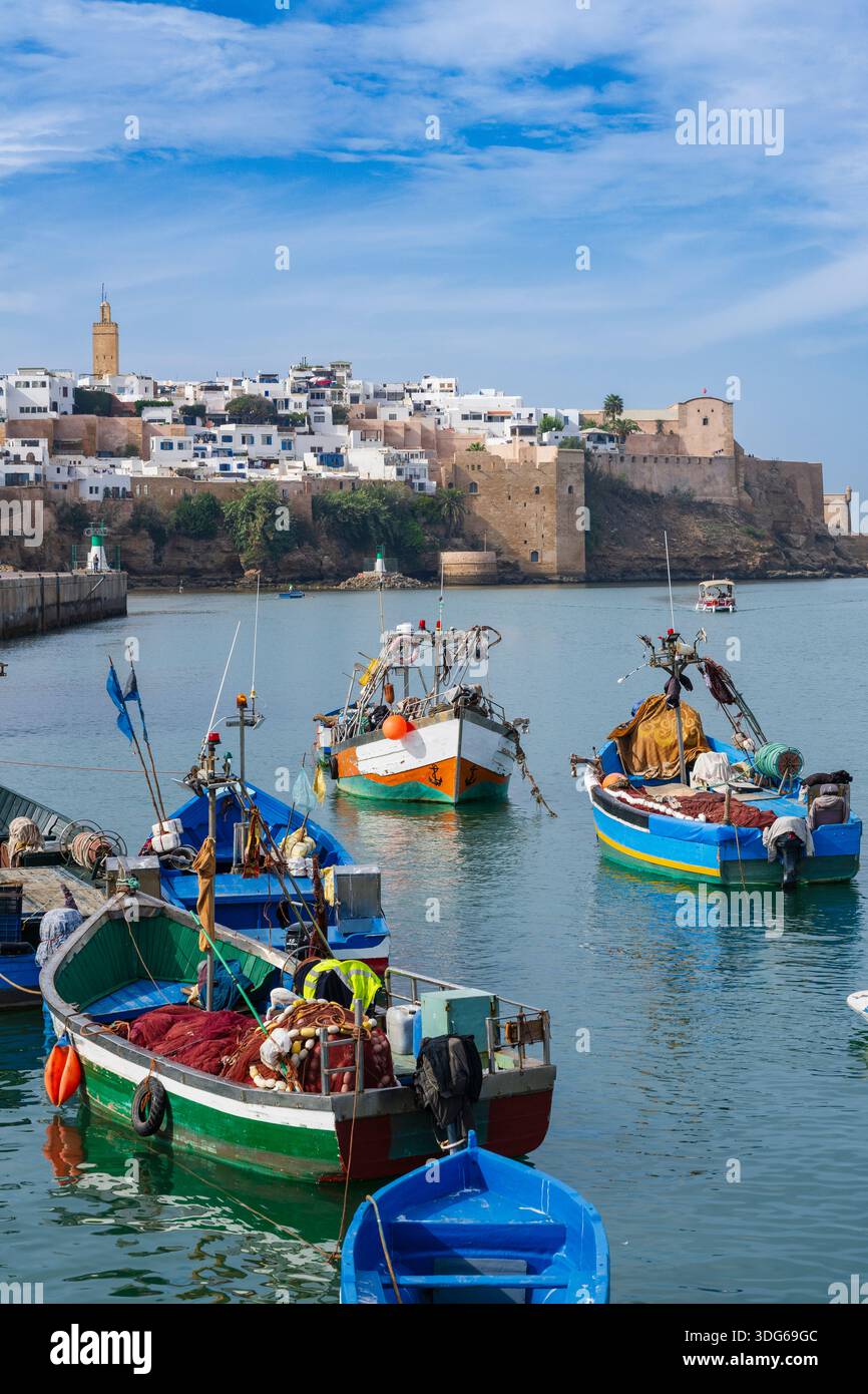 Colorful fishing boats float in a serene harbor, with white buildings ...