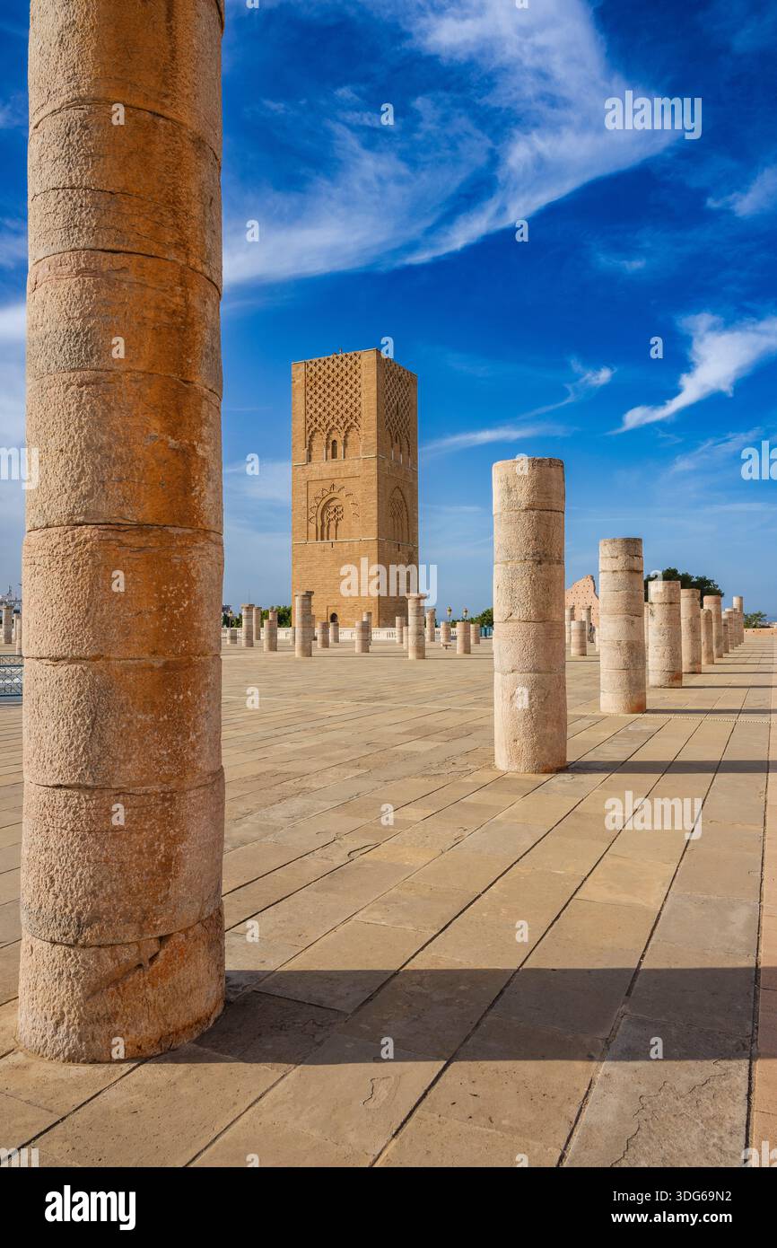 Tall stone pillars and a historic tower under a vibrant blue sky with ...