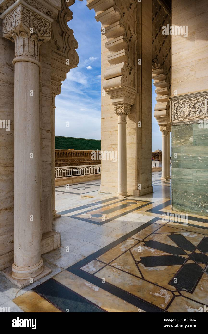 Intricately carved stone arches cast shadows on a patterned marble ...