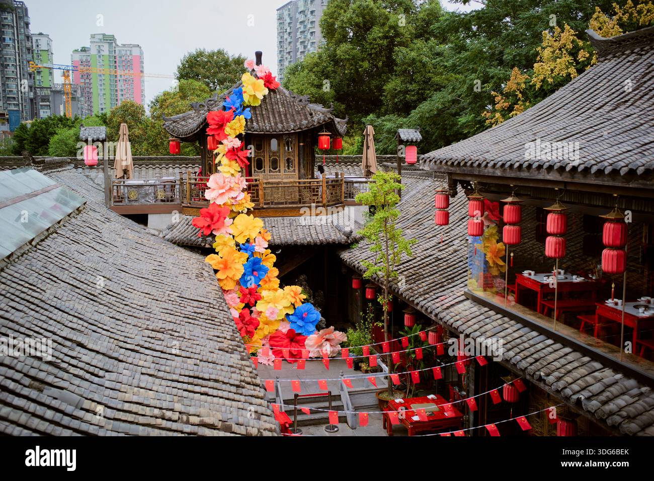 Vibrant floral display flows down traditional architecture amidst lush ...