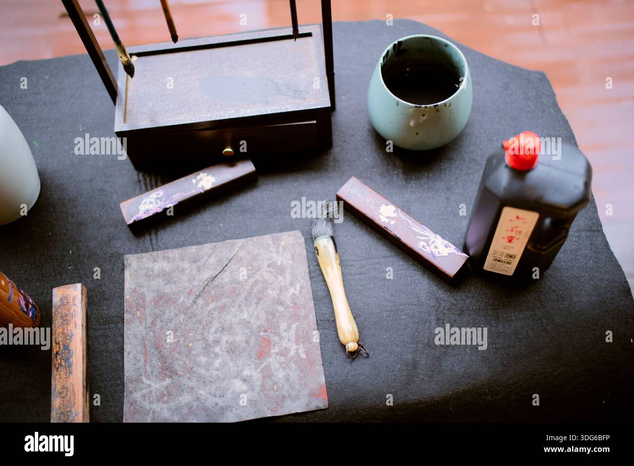 Oriental writing set with inkstone, brush, and ink sticks on a dark ...