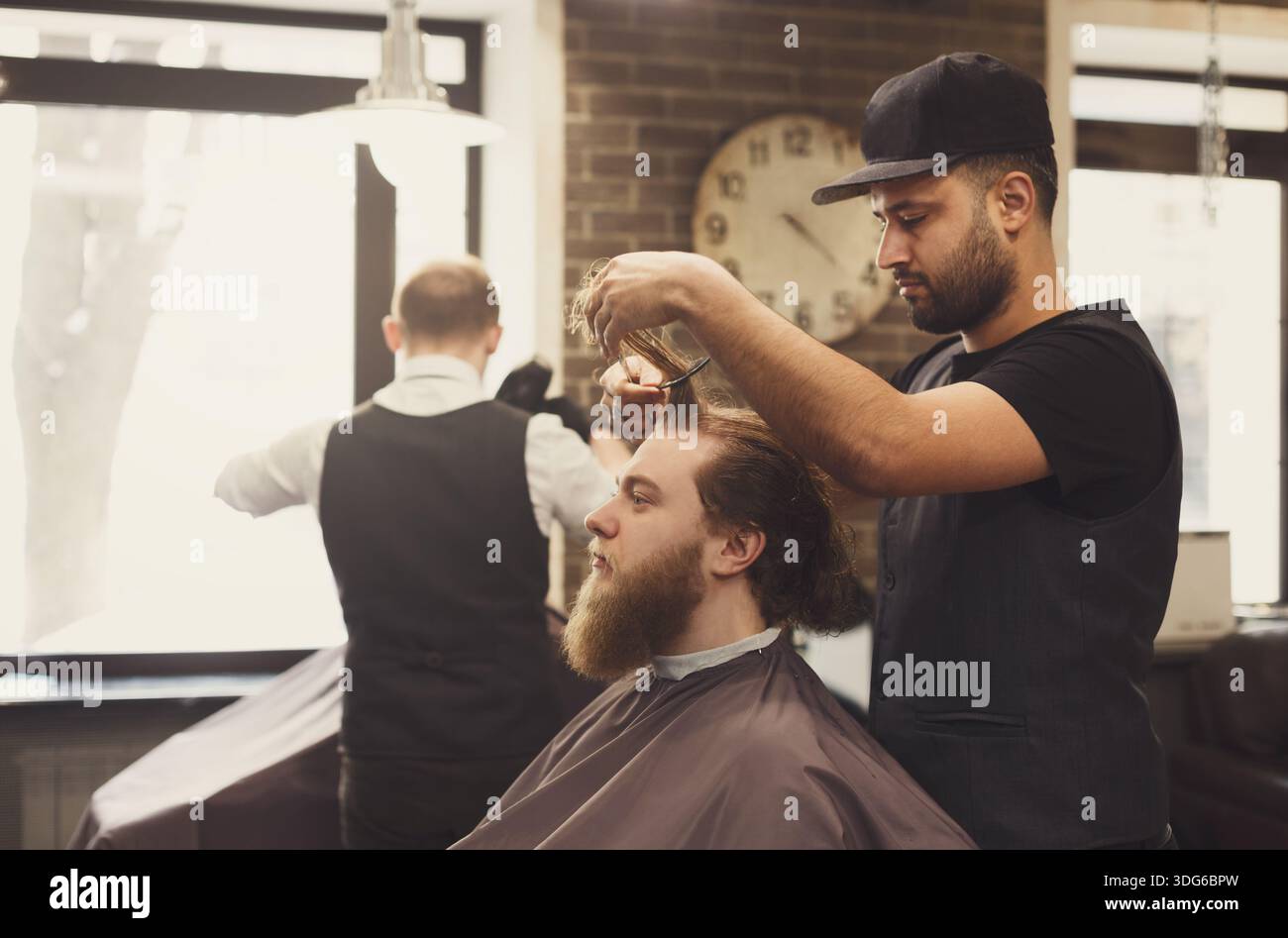 Man getting haircut by hairstylist at barbershop Stock Photo - Alamy