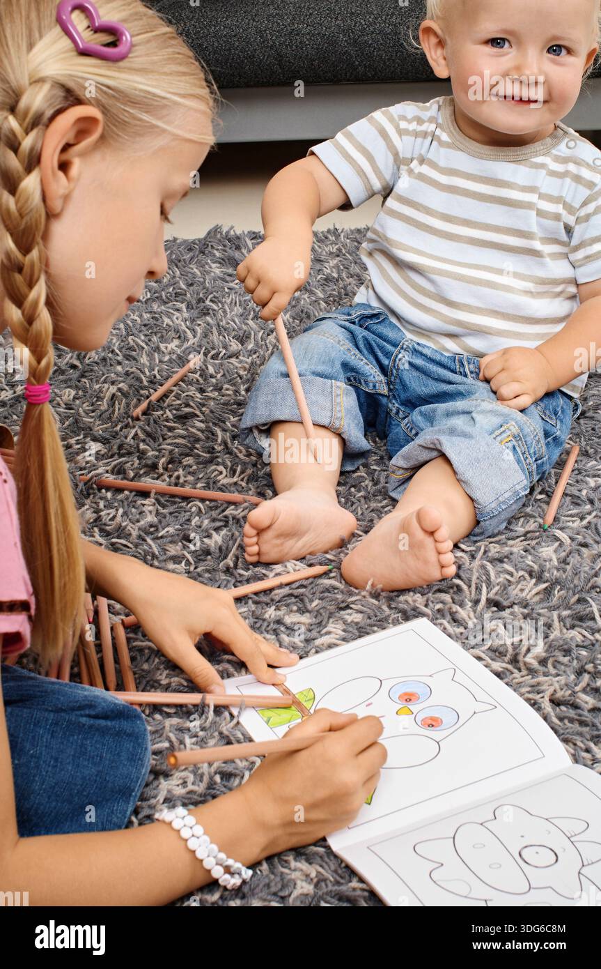 Children drawing with colored pencils on a plush carpet. Germany Stock ...