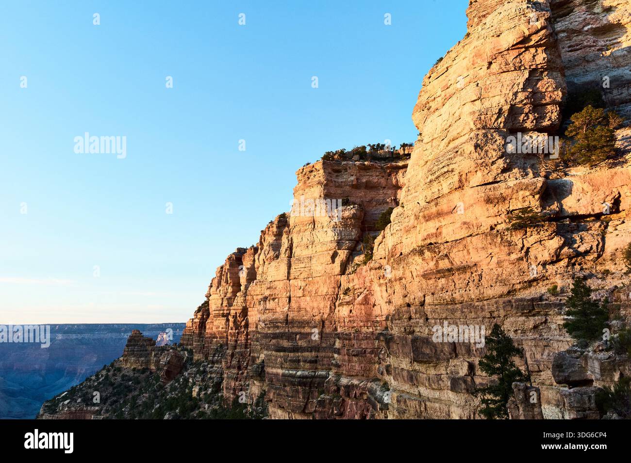 Majestic cliffs of the Grand Canyon illuminated by warm golden sunlight ...