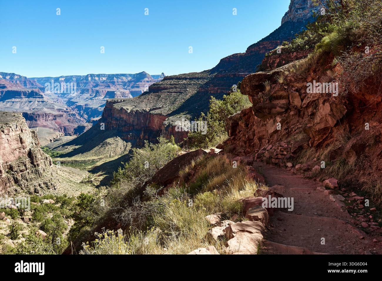 Rugged canyon landscape with a winding trail and clear blue sky. USA ...