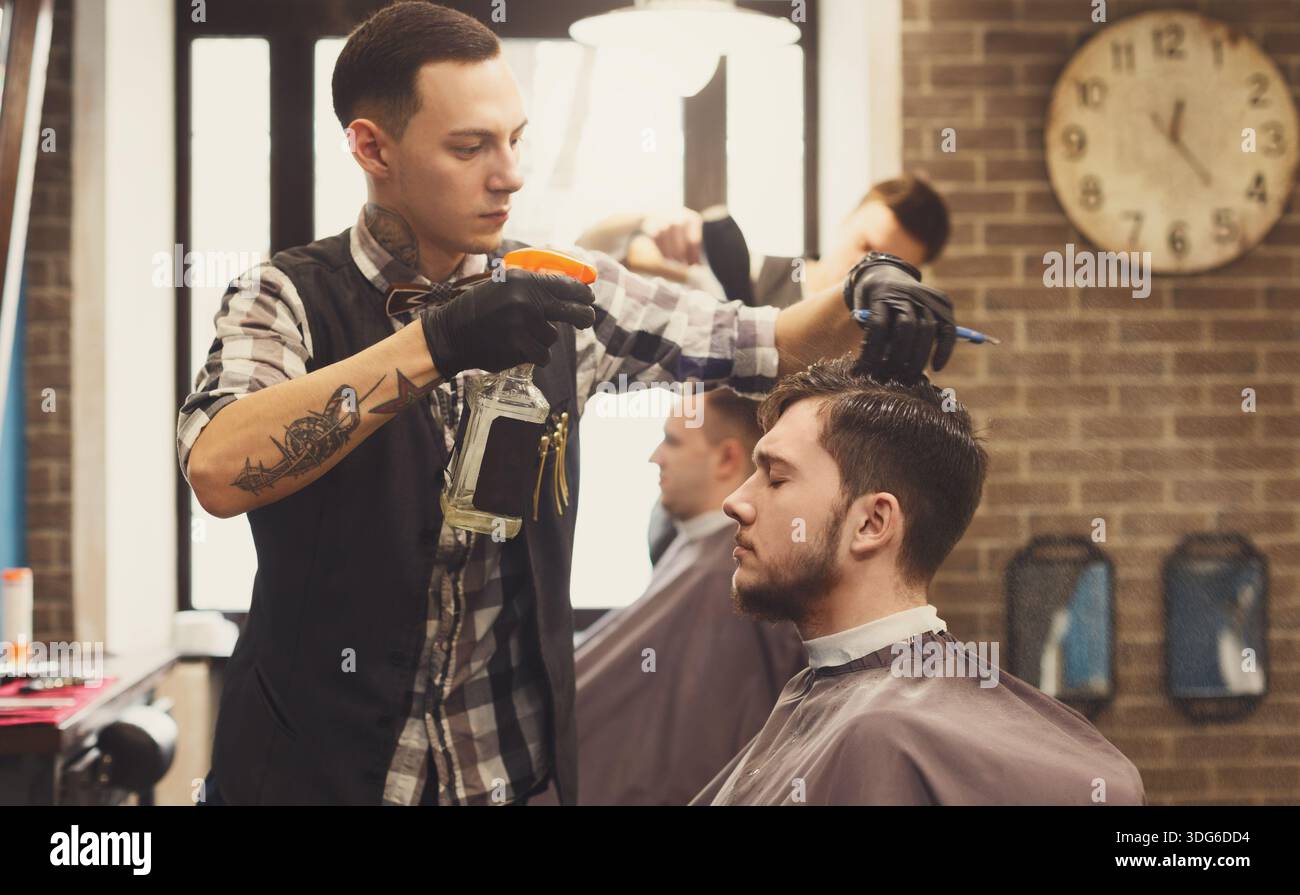 Man getting haircut by hairstylist at barbershop Stock Photo - Alamy