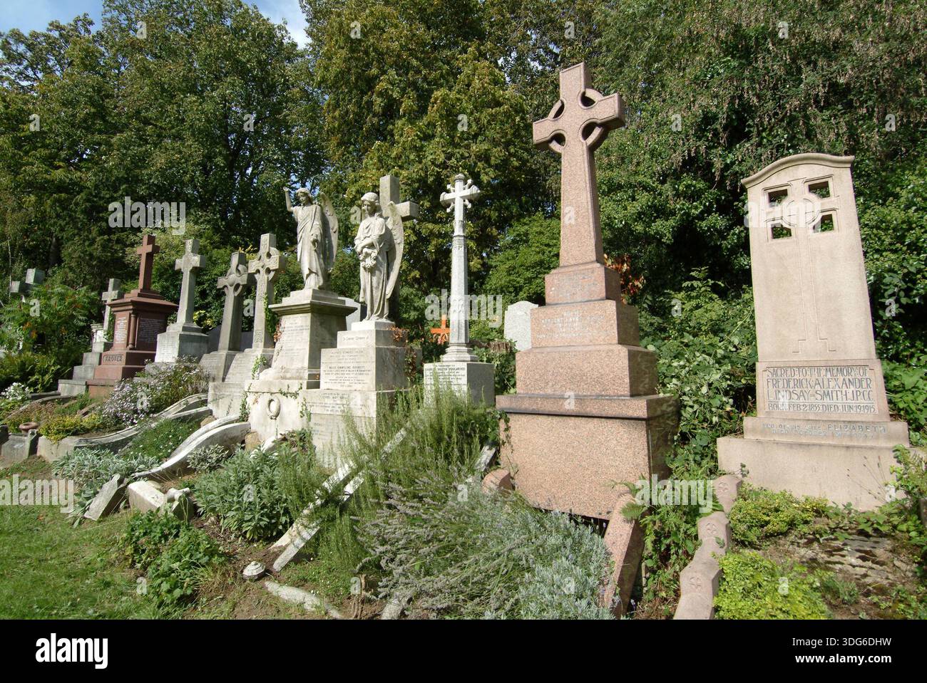 Weathered gravestones and ornate tombs within an overgrown Victorian ...