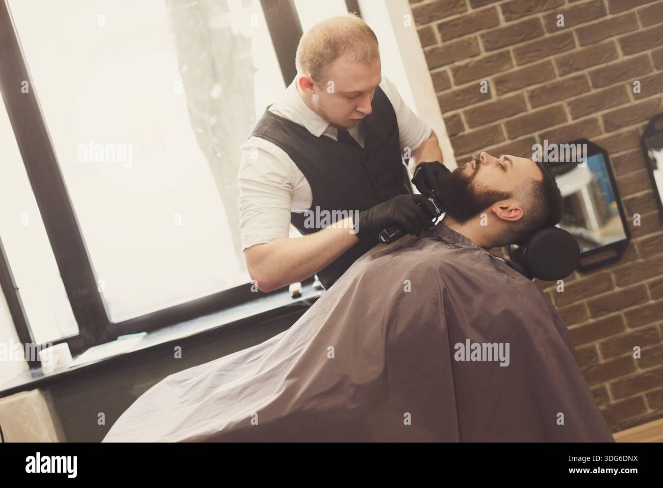 Man getting haircut by hairstylist at barbershop Stock Photo - Alamy