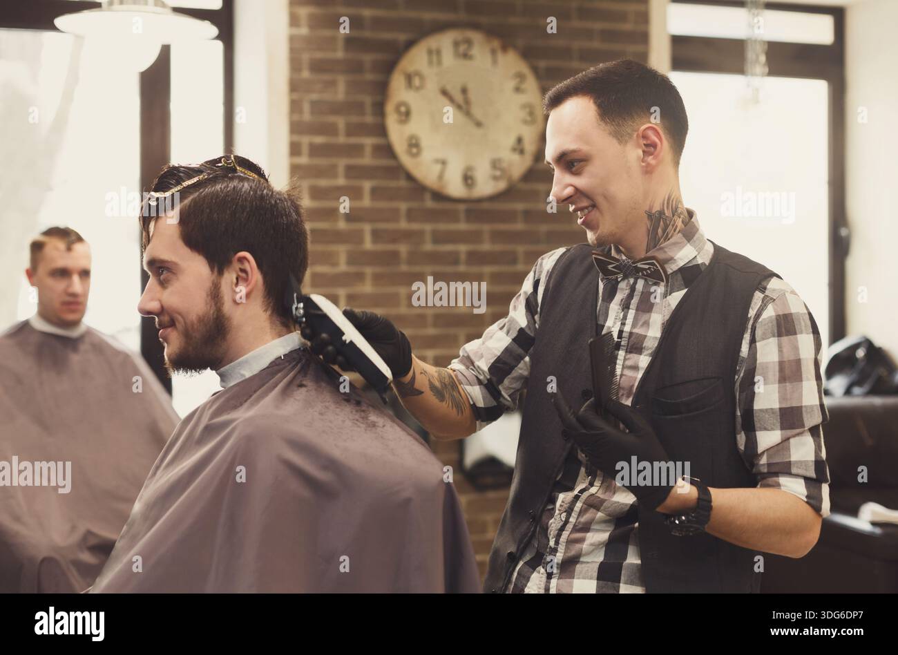Man getting haircut by hairstylist at barbershop Stock Photo - Alamy