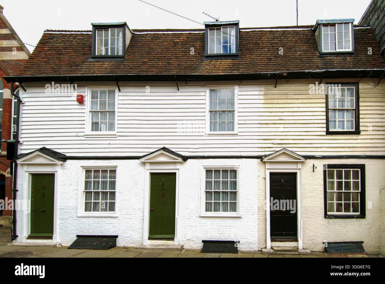 Clapboard weatherboard houses lining a narrow cobbled street in a ...