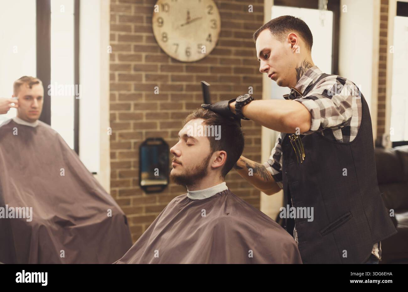 Man getting haircut by hairstylist at barbershop Stock Photo - Alamy
