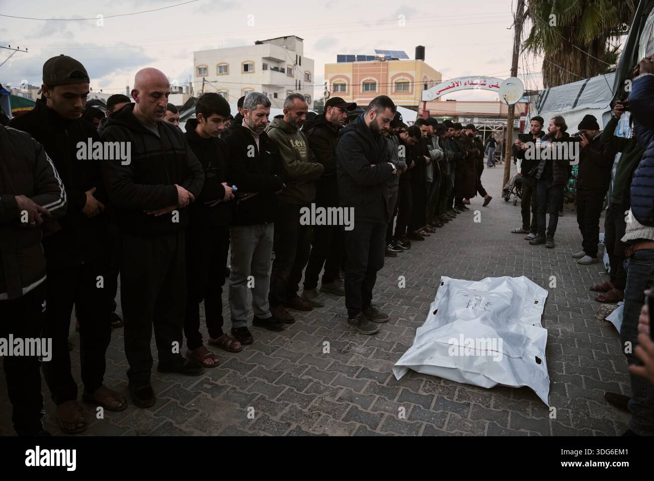 Palestinians pray beside the body of Saeed Al-Jaro, killed in an ...