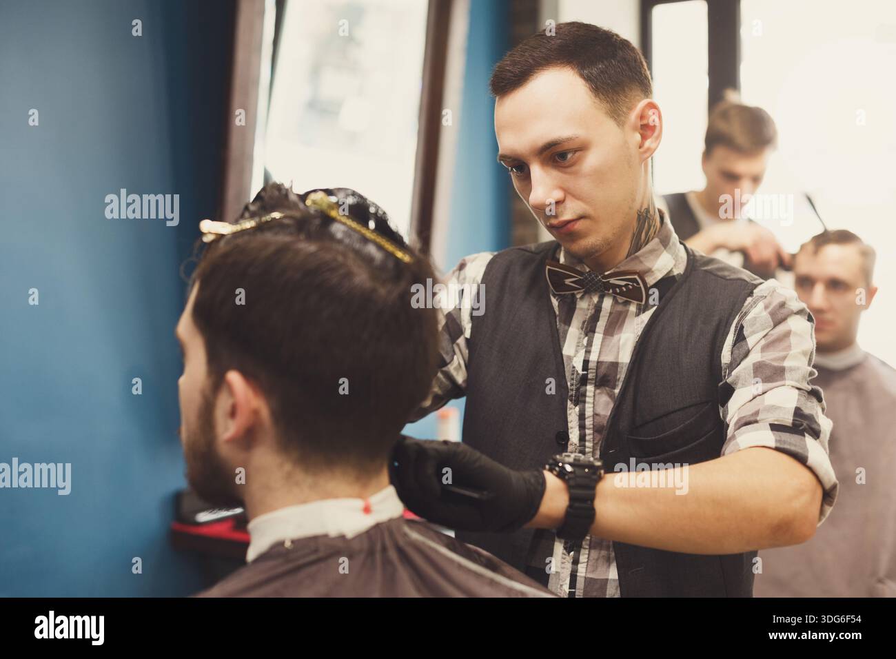Man getting haircut by hairstylist at barbershop Stock Photo - Alamy