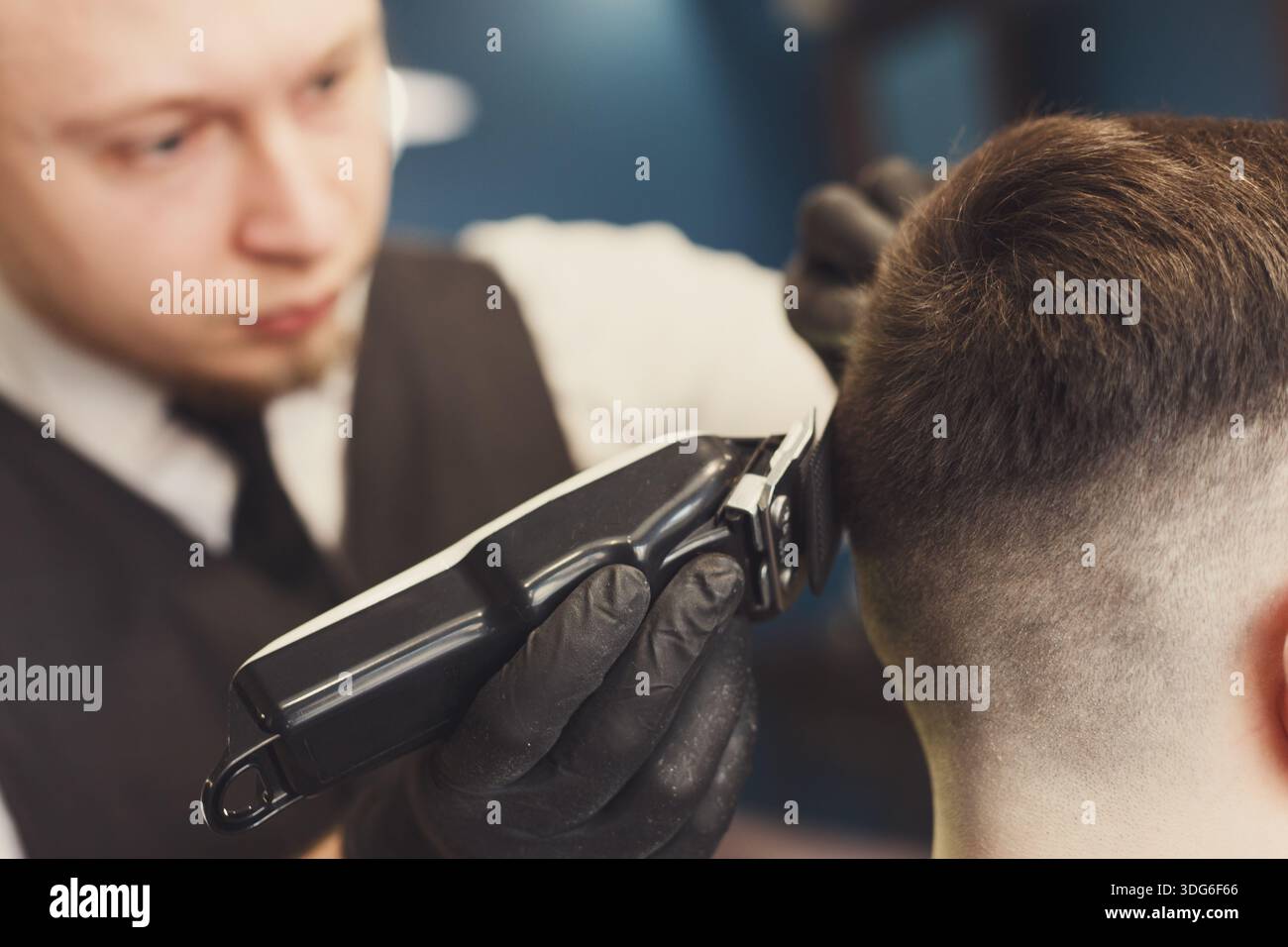 Man getting haircut by hairstylist at barbershop Stock Photo - Alamy