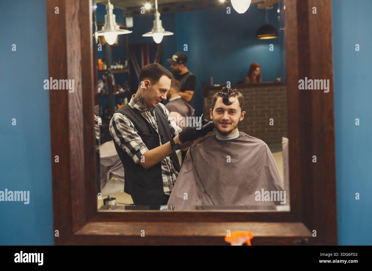 Man getting haircut by hairstylist at barbershop Stock Photo - Alamy