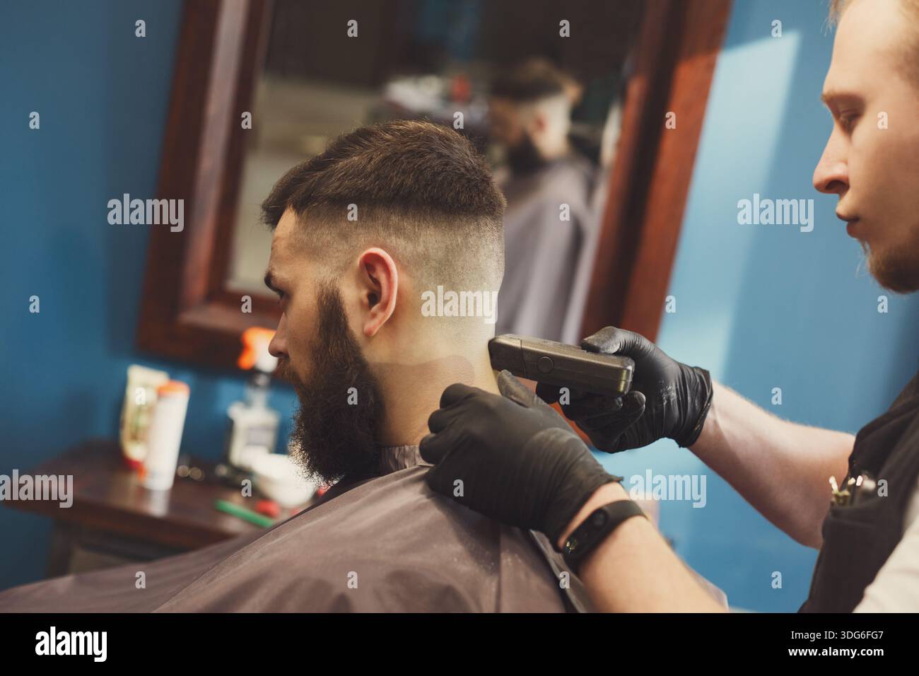 Man getting haircut by hairstylist at barbershop Stock Photo - Alamy