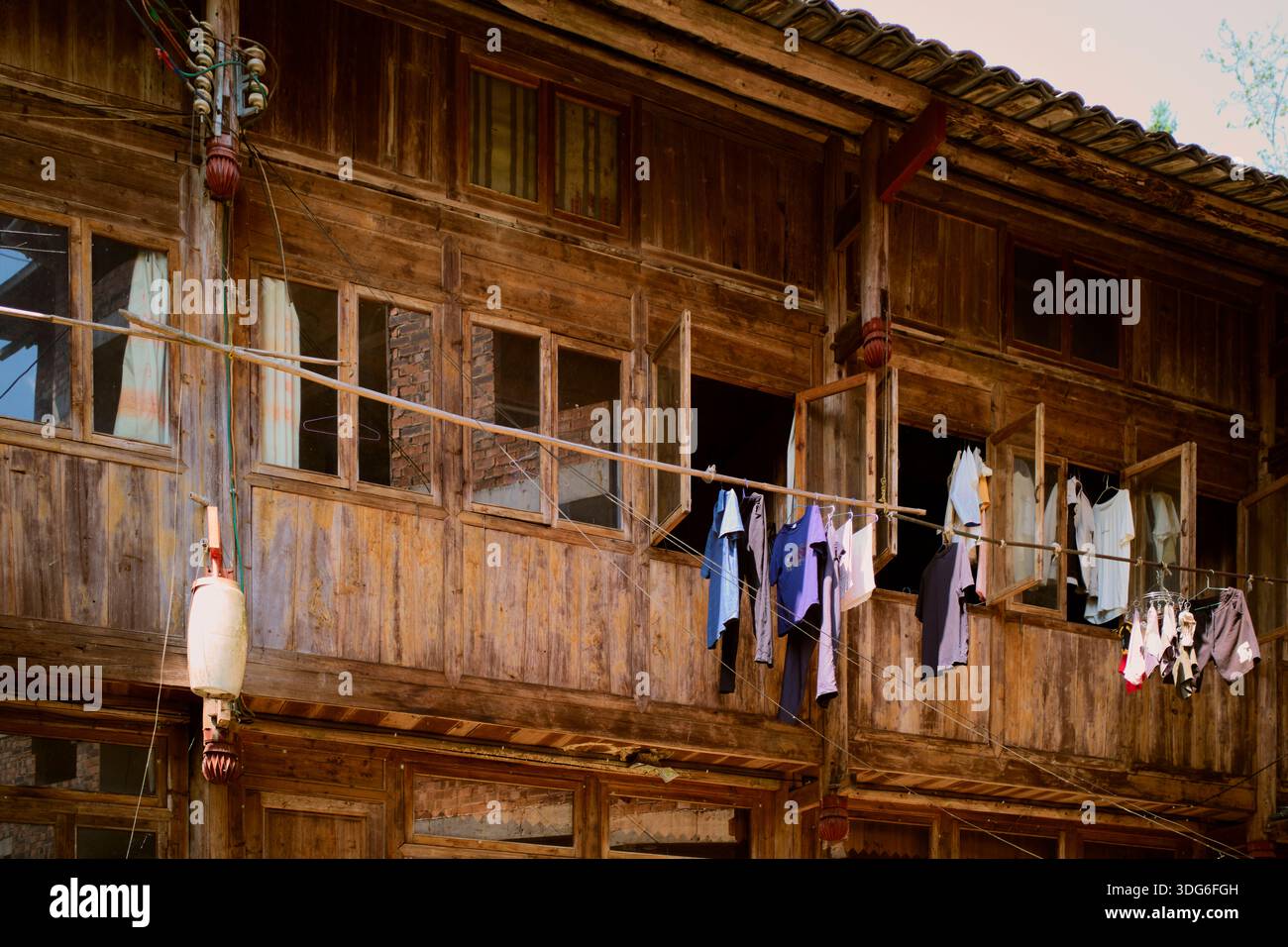 Rustic wooden building with laundry hanging outside windows on a sunny ...