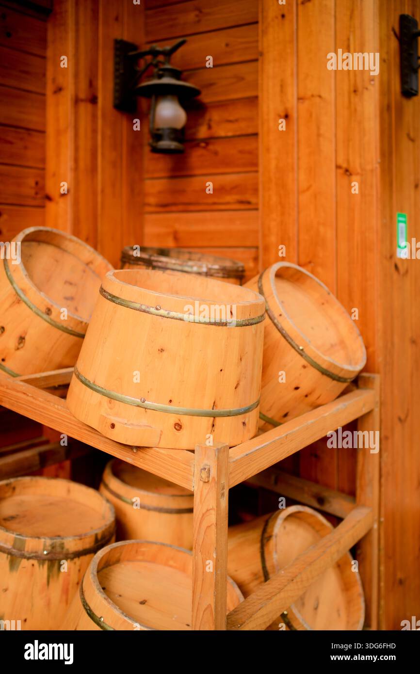 Wooden barrels stacked on a wooden shelf with a lantern on a wooden ...