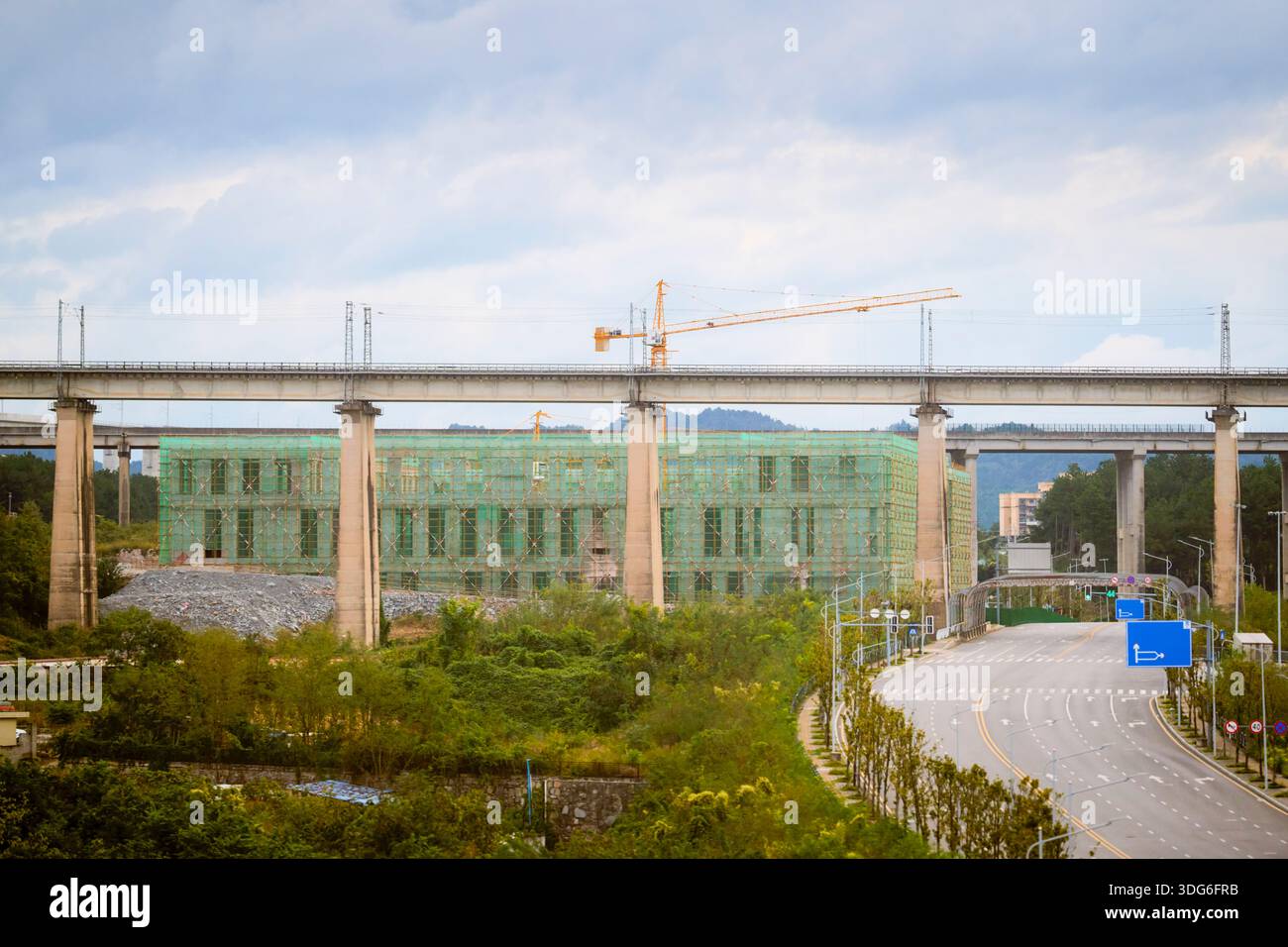 Construction site with green scaffolding viewed beneath a highway ...