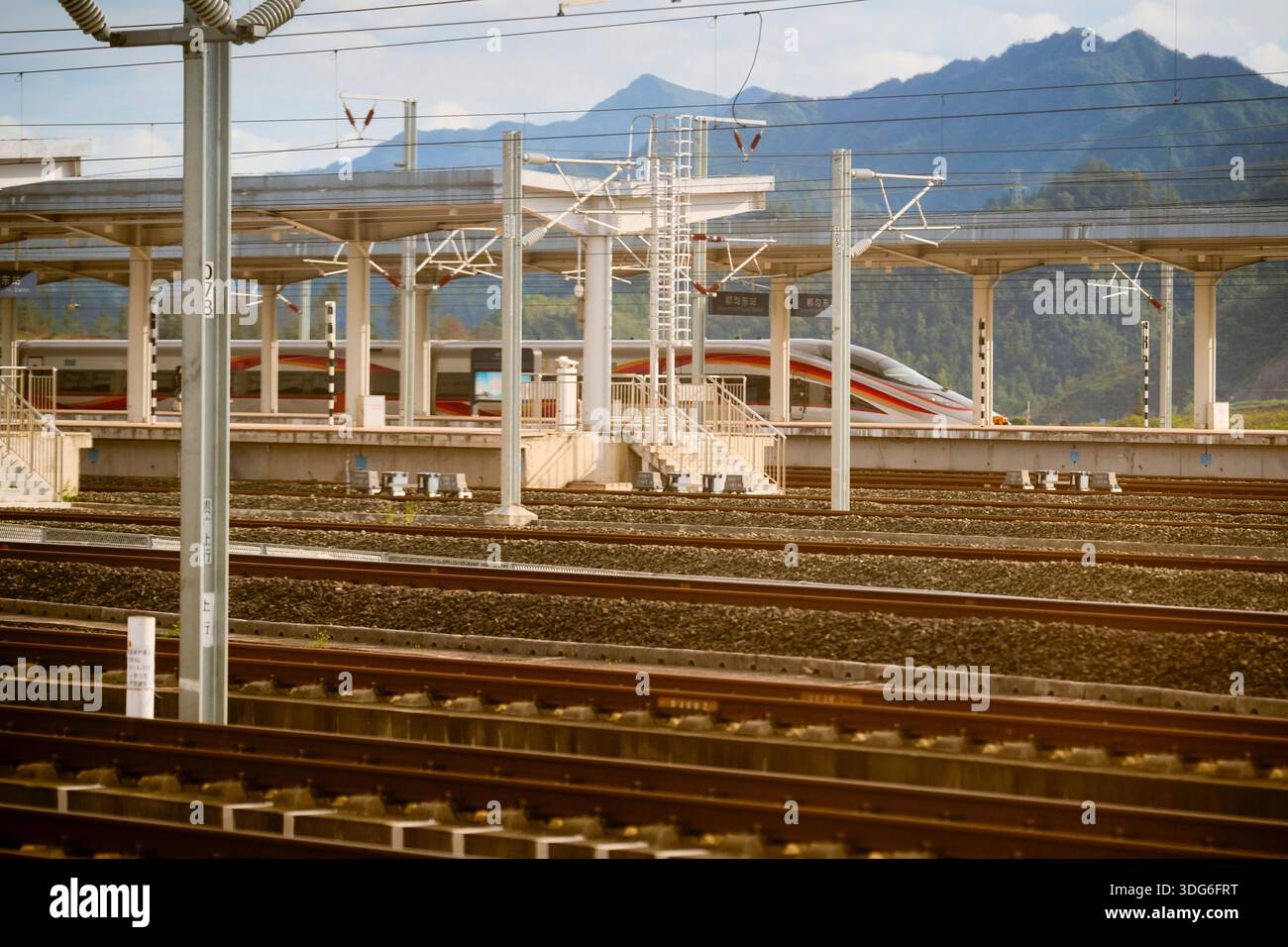 High-speed train at platform with mountains in the background on a ...