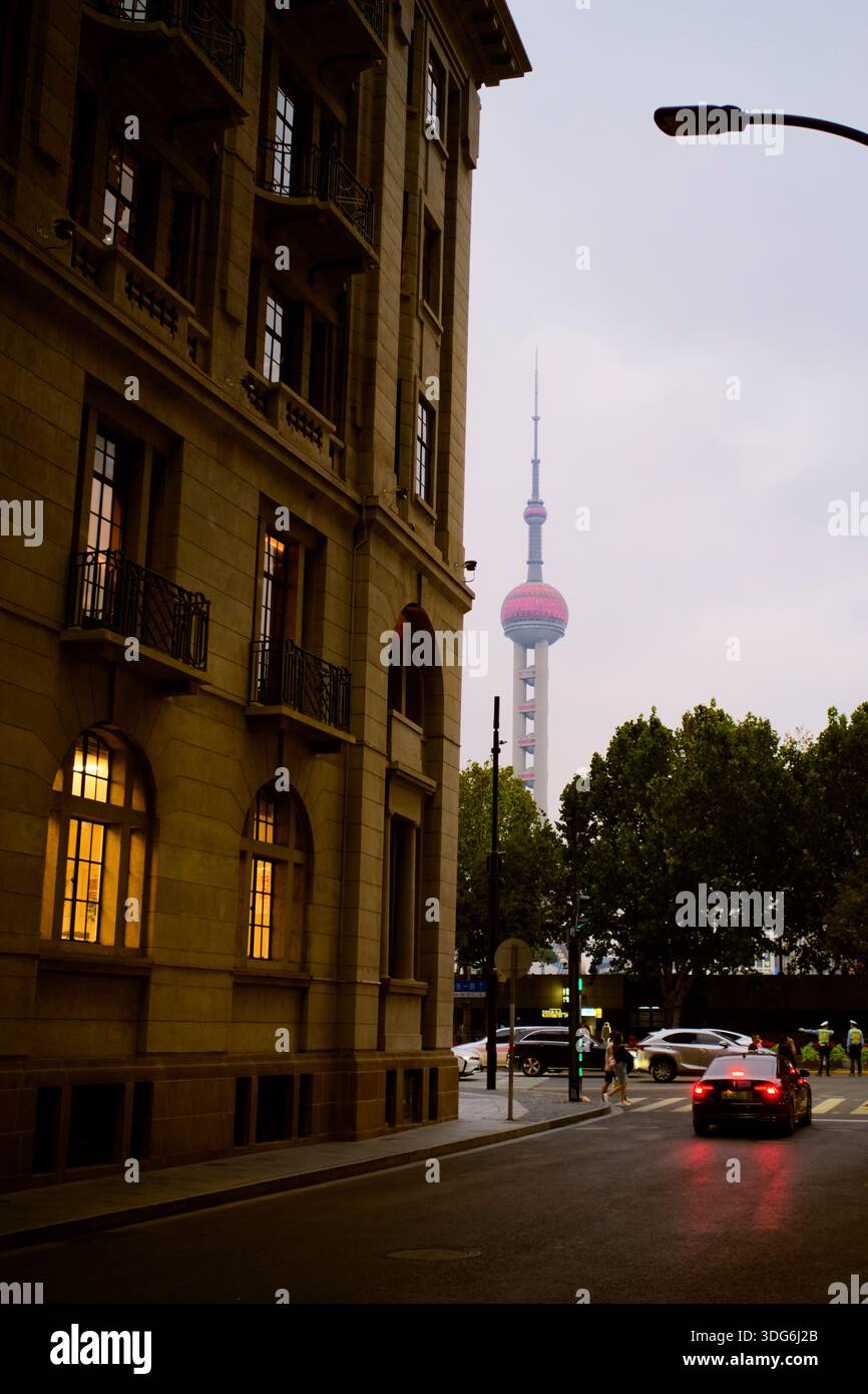 Evening view of a city street with a prominent tower in the background ...