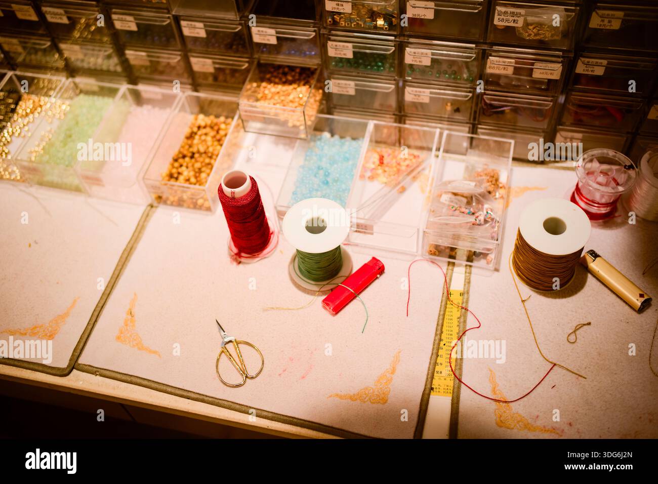 Craft workspace with colorful threads, beads, scissors, and organized ...