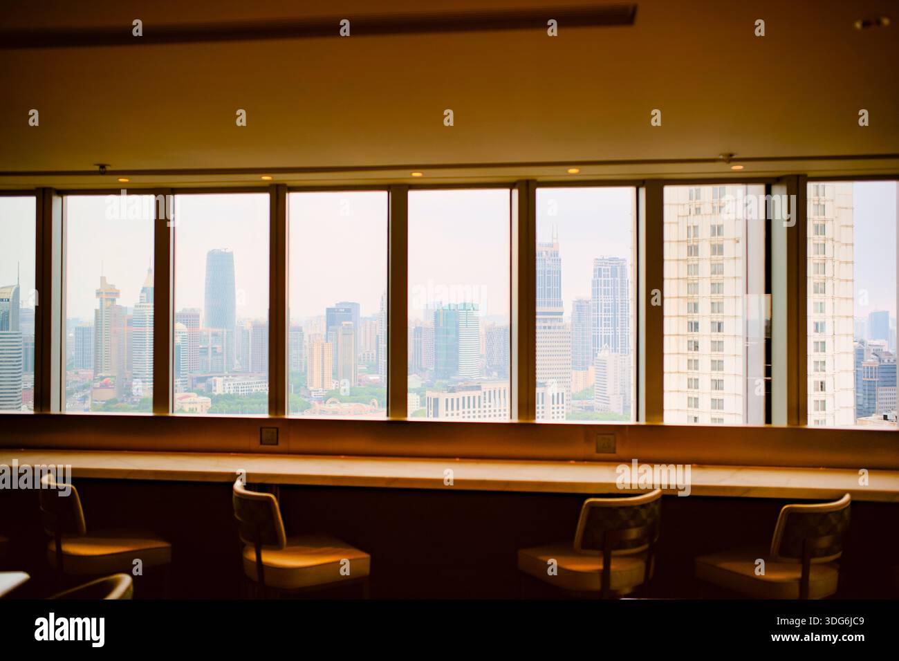 Empty cafe with city skyline views through large panoramic windows ...