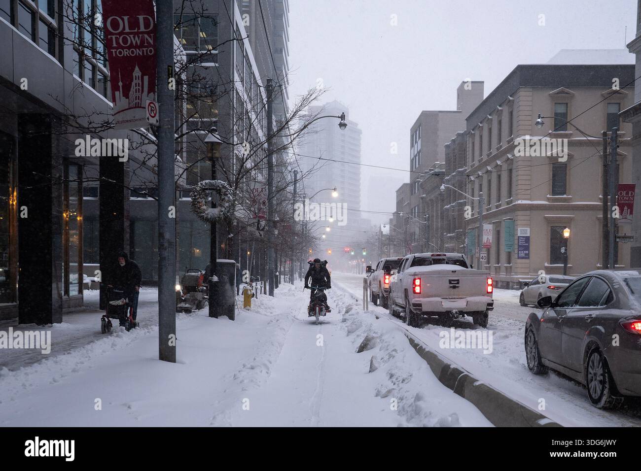 A cargo cyclist rides along Adelaide Street East amid heavy snowfall ...