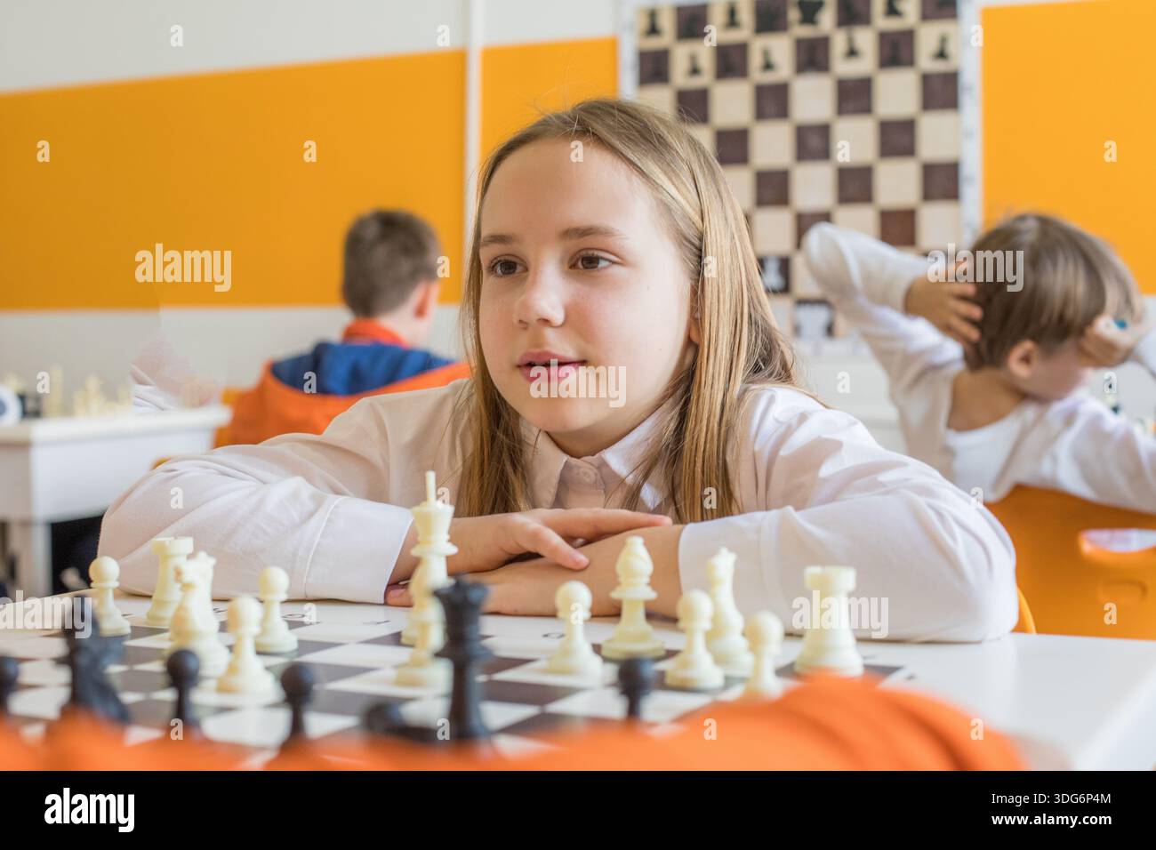Smart schoolgirl playing chess game in school classroom. Child girl on ...