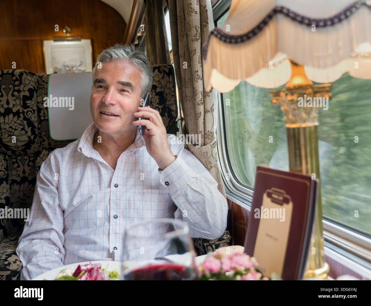 LUXURY TRAVEL LIFESTYLE TRAIN FIRST CLASS RED WINE Relaxed happy mature ...