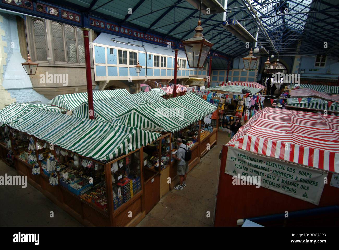 A bustling indoor market filled with local vendors and shoppers engaged ...