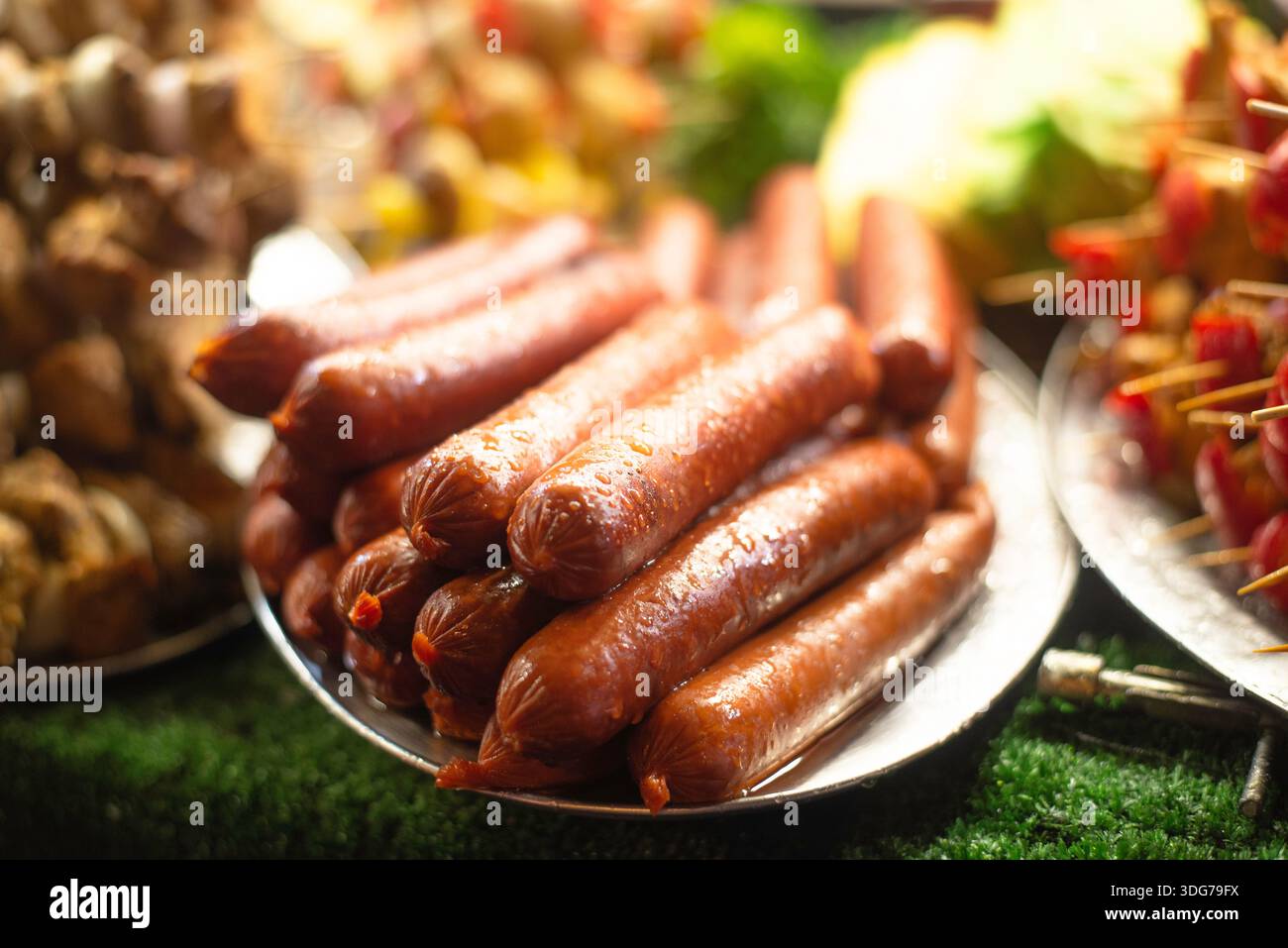 Close-up of grilled smoked sausages on a metal plate at a street food ...