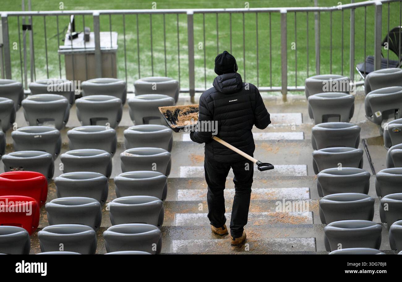 Employee sprinkling sand on the stairs and ramps, Allianz Arena Munich ...