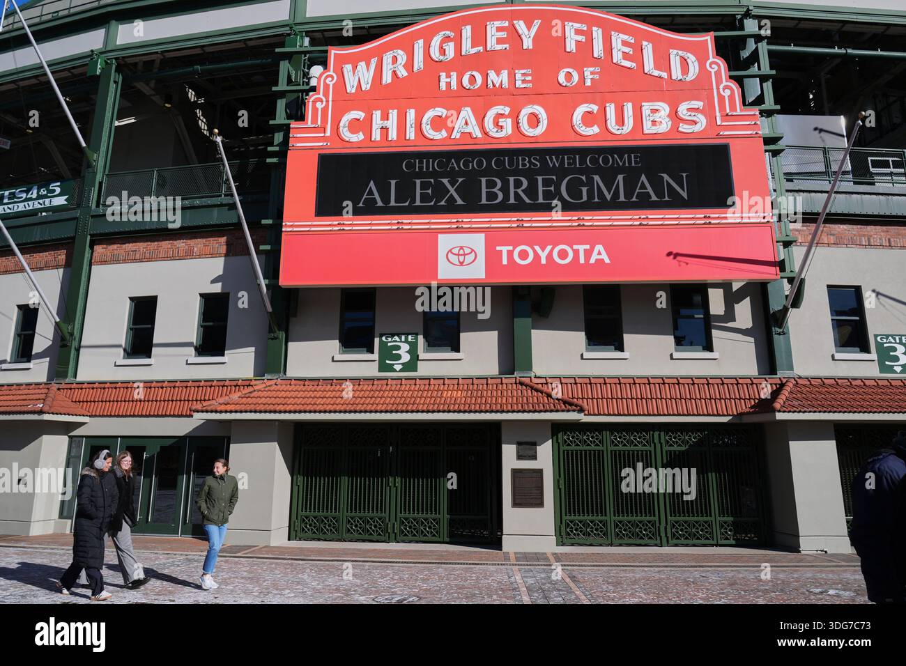 People walk by the front of Wrigley Field in Chicago, where the marquee ...