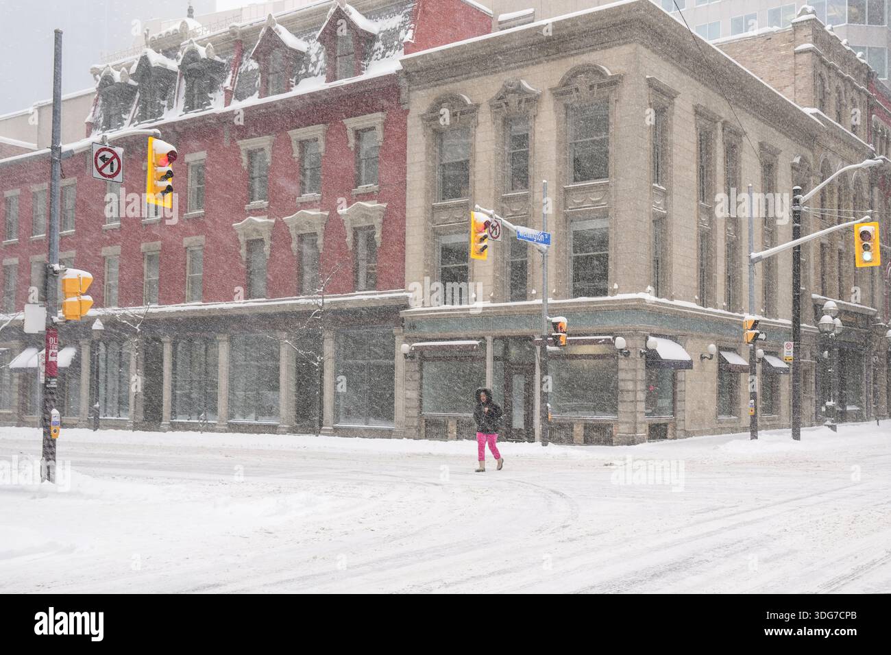 A pedestrian crosses at Yonge Street and Wellington Street in downtown ...