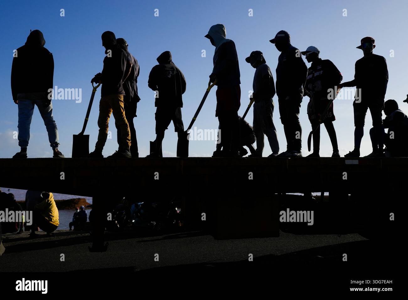 People work at the Salinas de Cumaraguas salt flats on the Paranguana ...