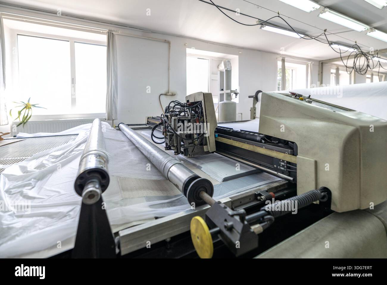 Industrial CNC cutting machine processing white fabric. High precision ...