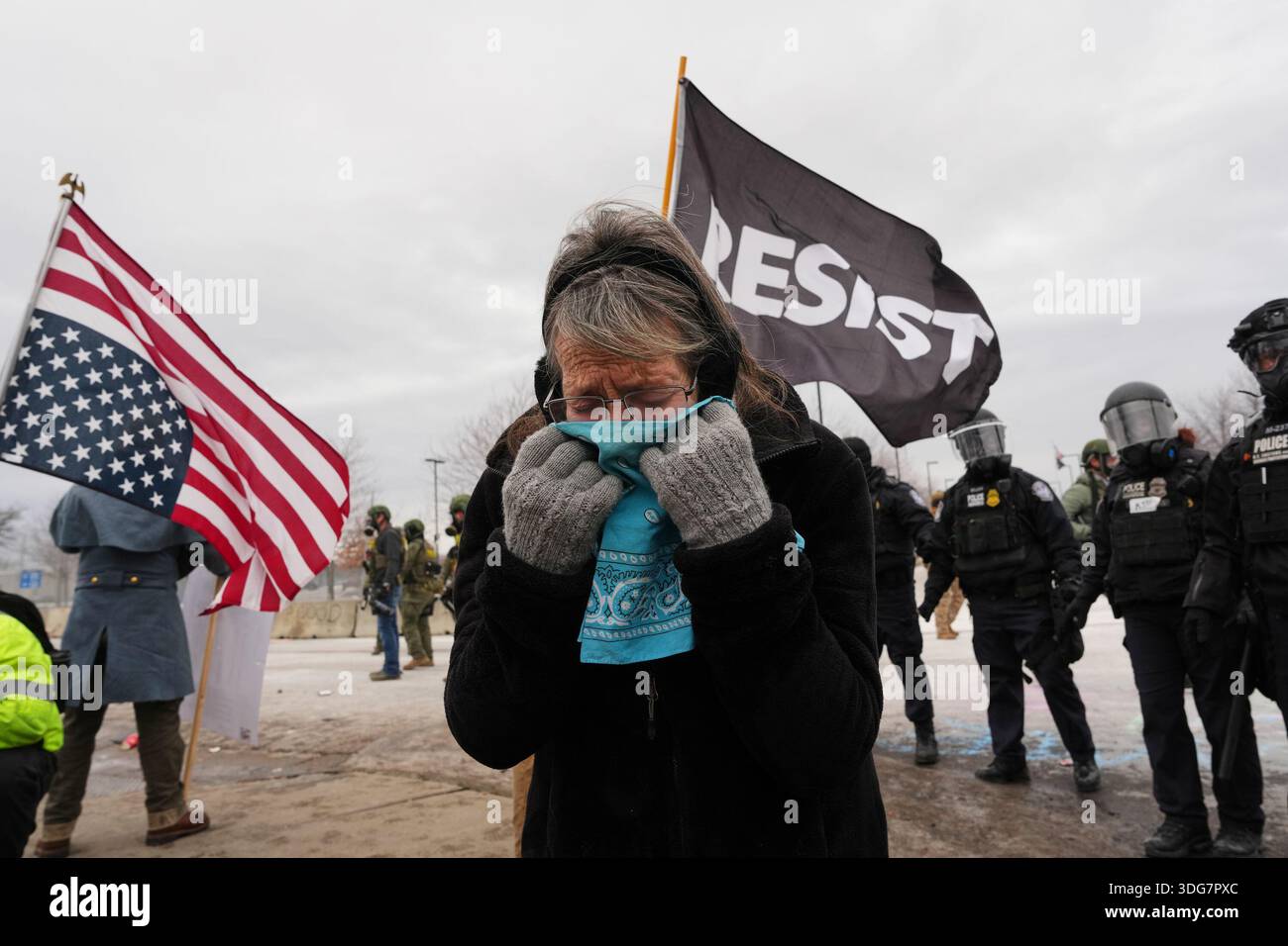 A woman covers her face from tear gas as federal immigration officers ...