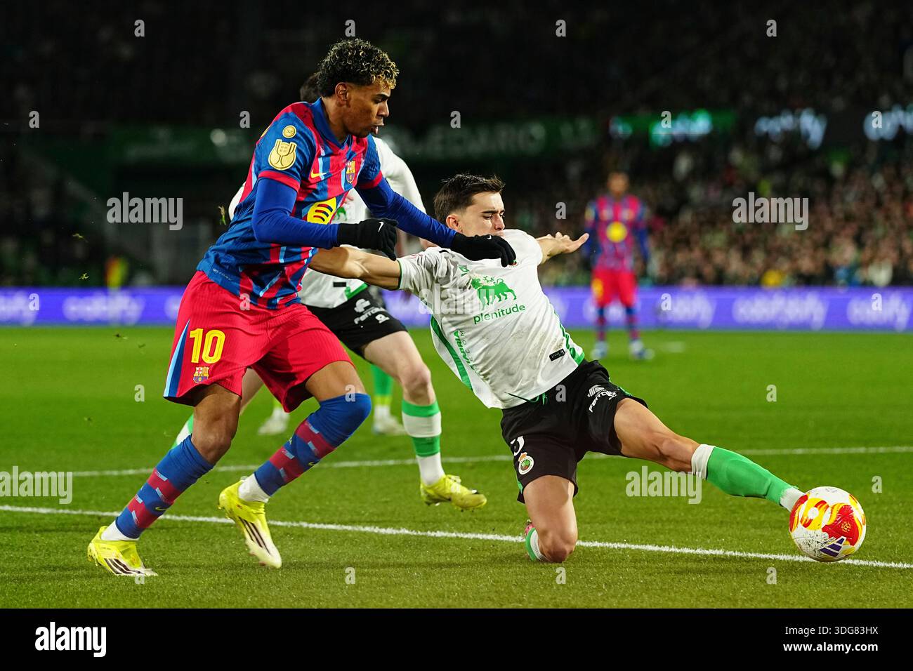 Barcelona's Lamine Yamal, left, vies for the ball with Racing Santander ...