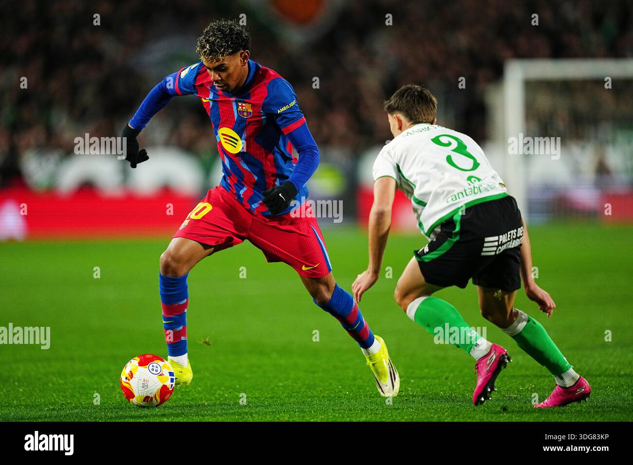 Barcelona's Lamine Yamal, left, vies for the ball with Racing Santander ...