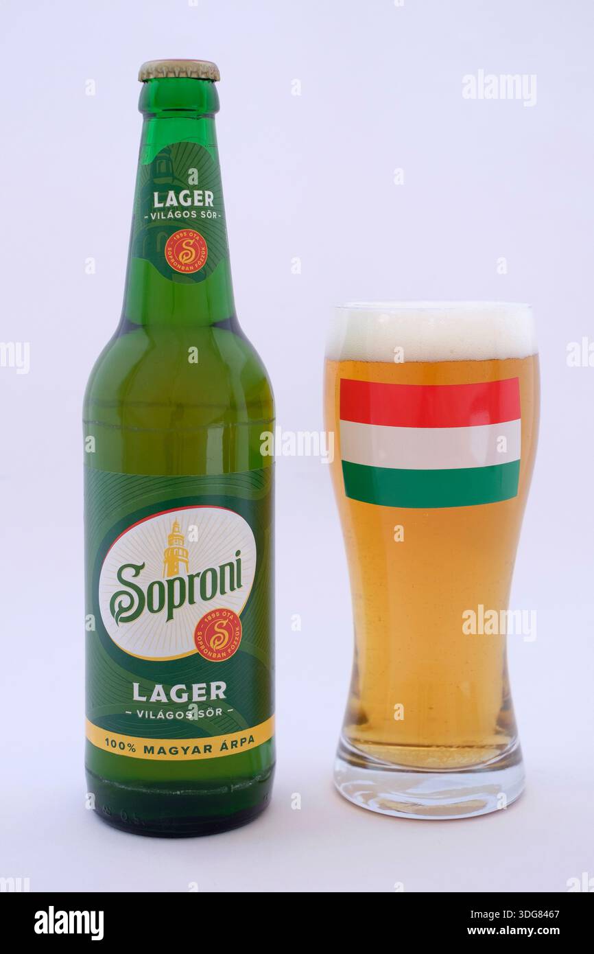 full beer glass with hungarian tricolour flag logo next to bottle of ...