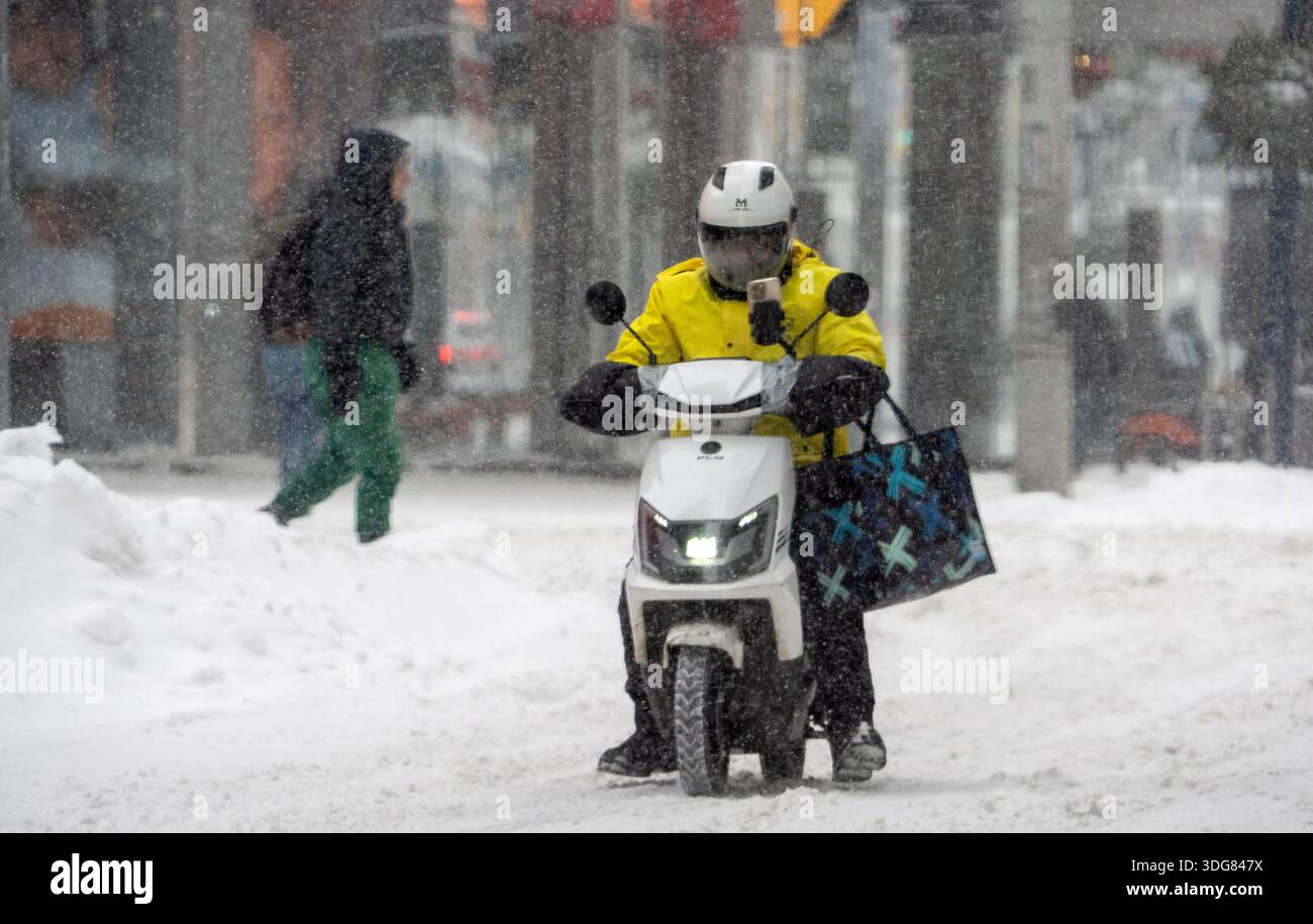 A food delivery driver on an E-Bike makes his way through heavy snow in ...
