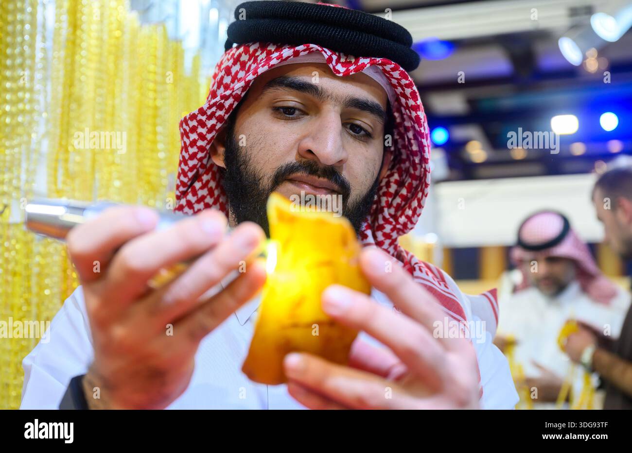 A customer checks the quality of raw amber at a stall during the Katara ...